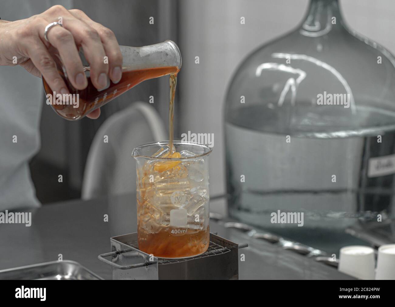 Barista hand holding Lab Borosilicate Glass Beaker Mixing tea drink ...