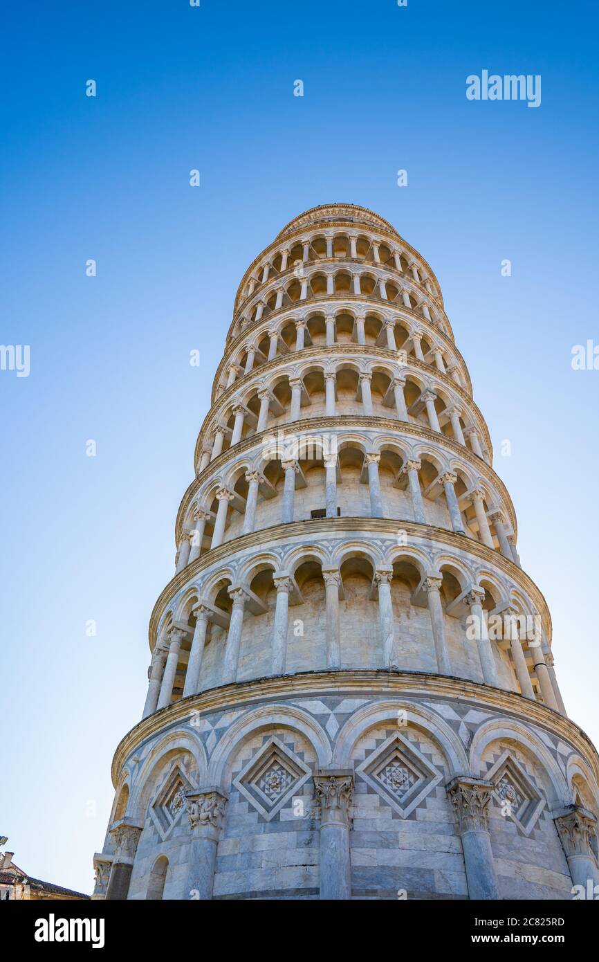 Vertical low angle shot of the famous leaning Pisa tower under a bright ...
