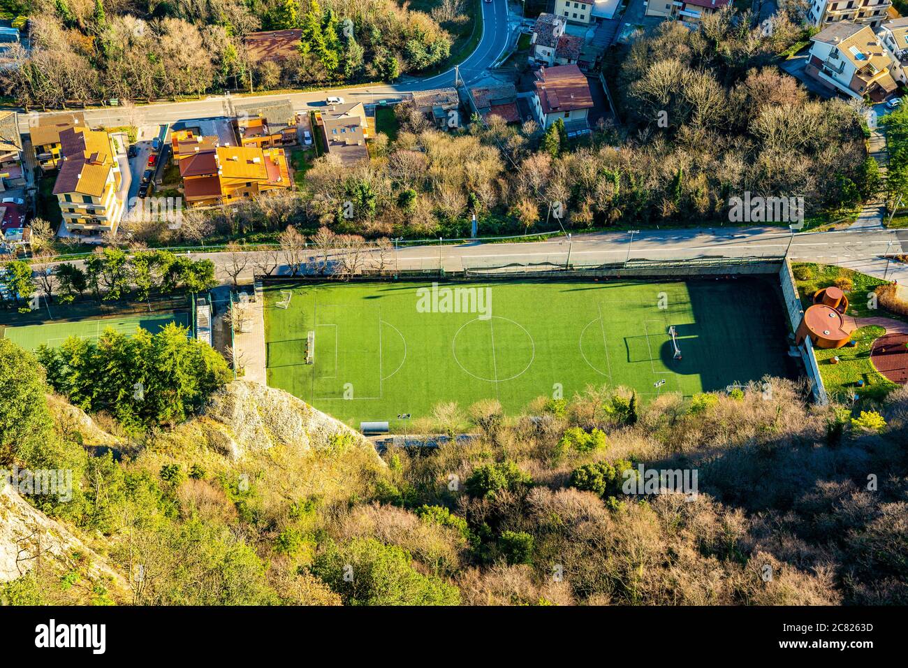 Aerial view of a bright green football field near the old town ...