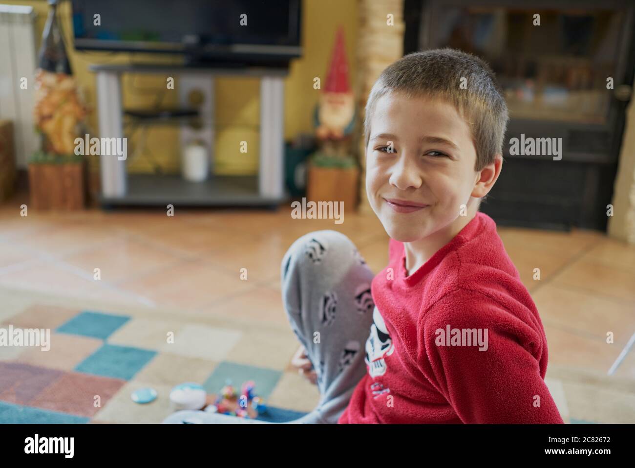 A shallow focus shot of a young boy smiling and looking at the camera ...
