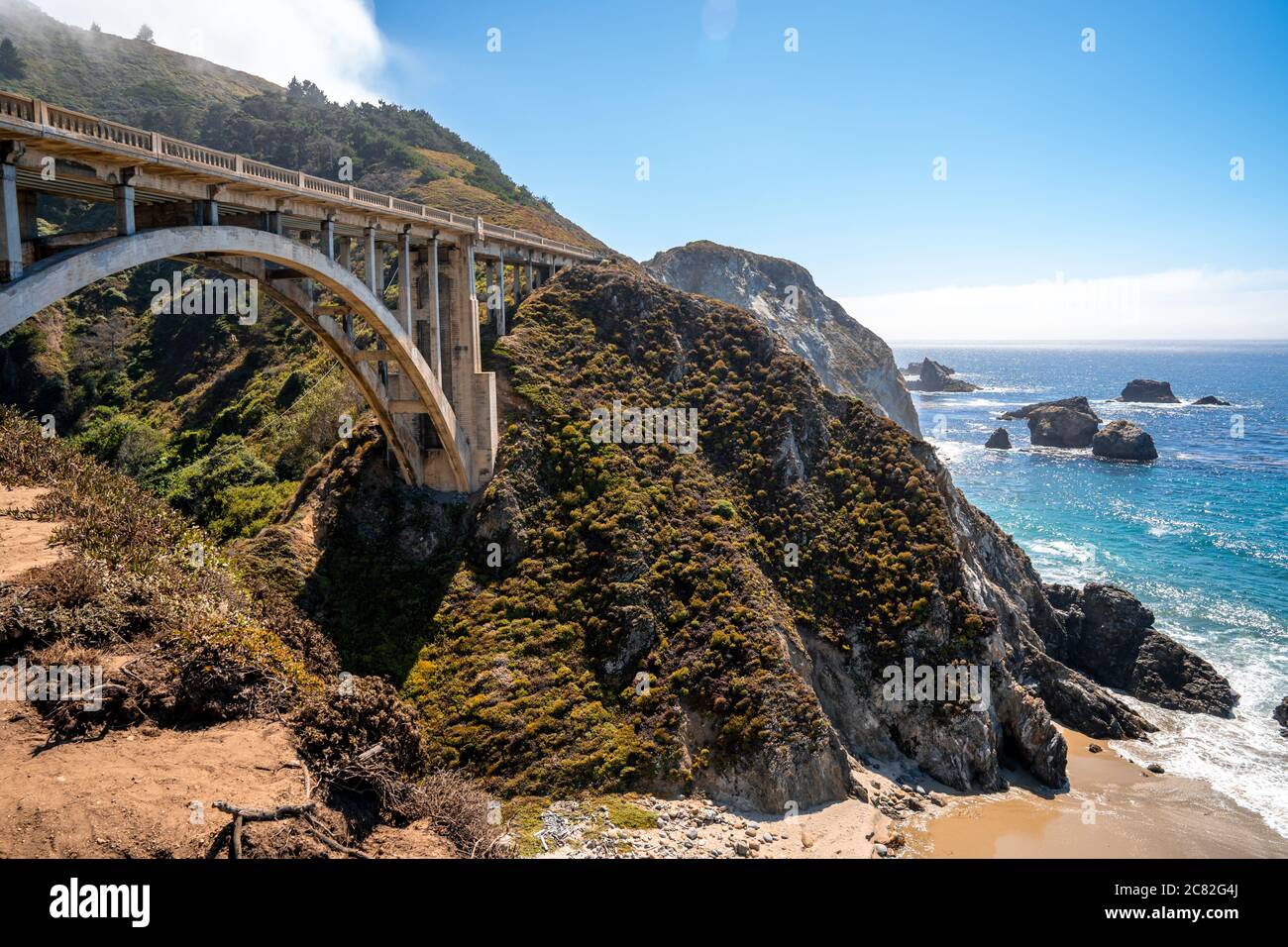 Closeup shot of a big bridge over a canyon with an ocean on the ...