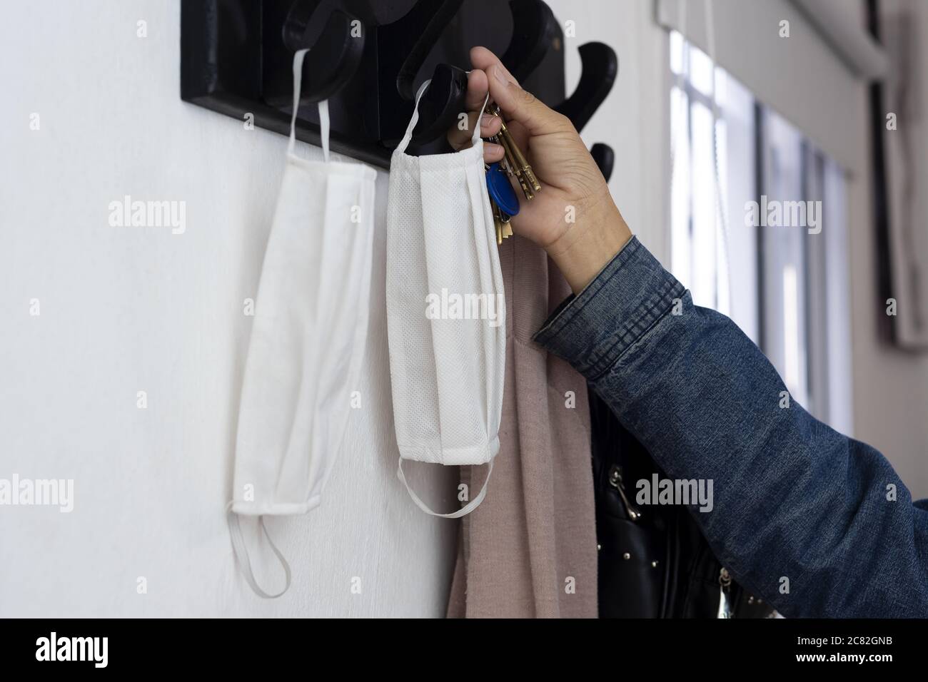 Male with a blue shirt hanging medical masks from a coat hanger Stock ...