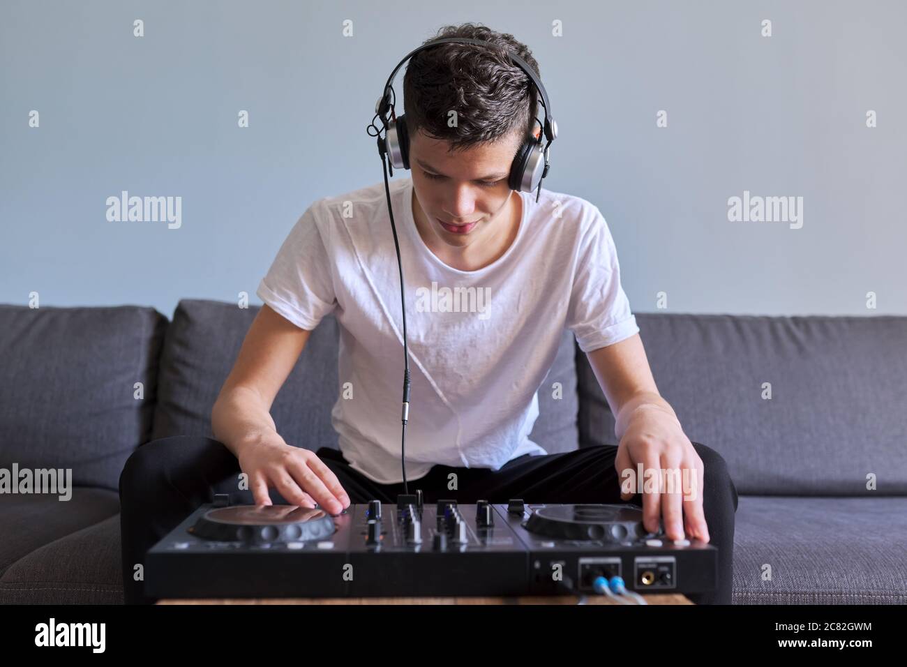 Creative teen boy in headphones with mixer equipment entertainment dj ...