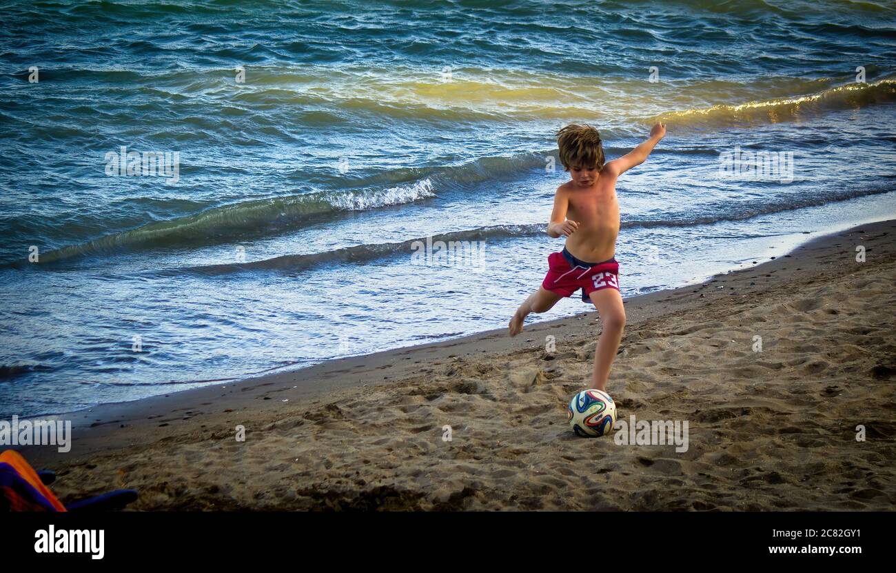 Costa del sol, Spain - September 02, 2015: A boy kicking a football on ...
