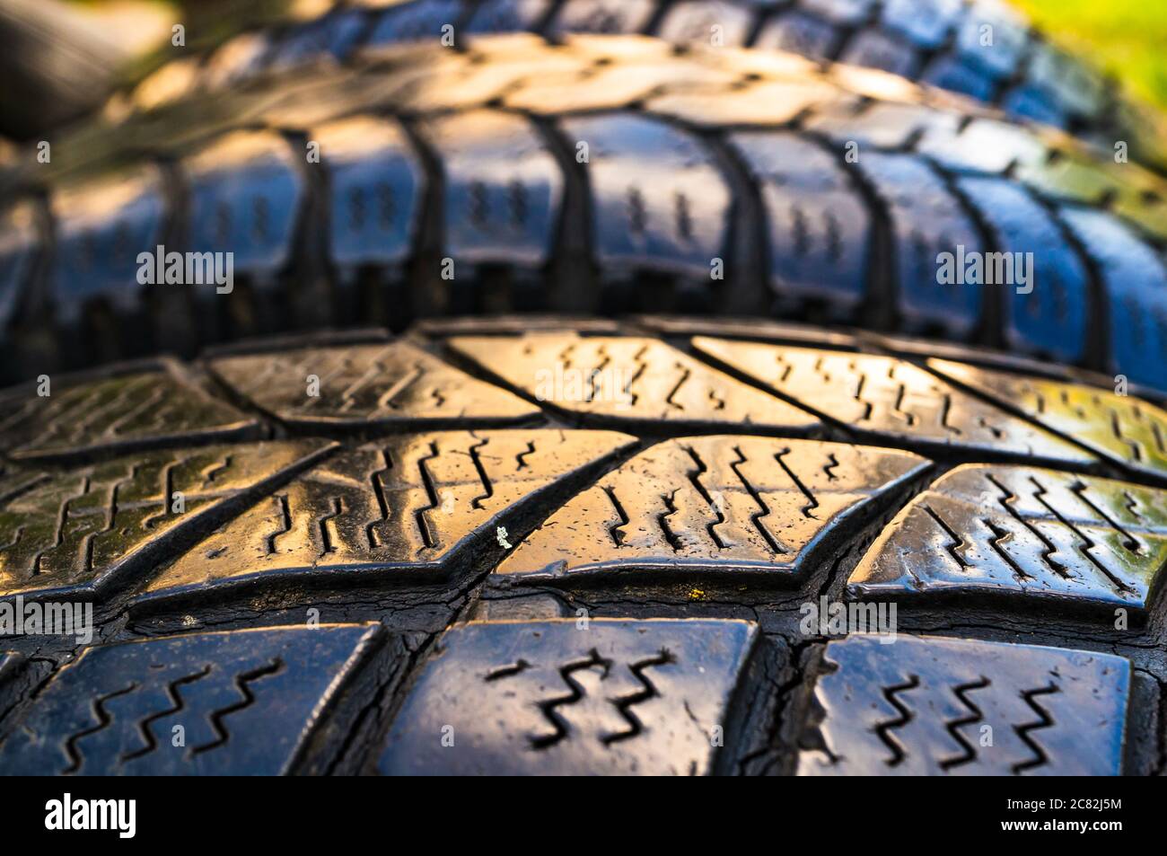 Closeup shot of old used worn car wheel tyres pile stacked in rows ...