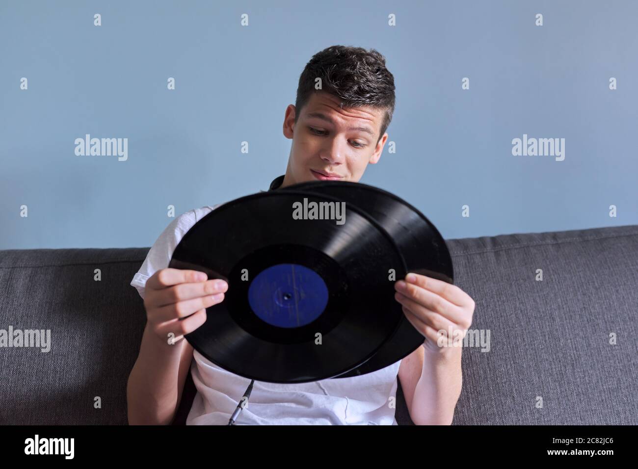 Creative teen boy with vinyl records, young man in headphones ...