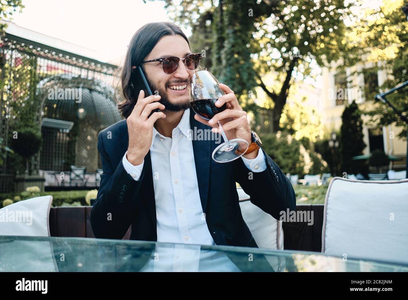 Young handsome smiling brunette bearded man happily talking on ...
