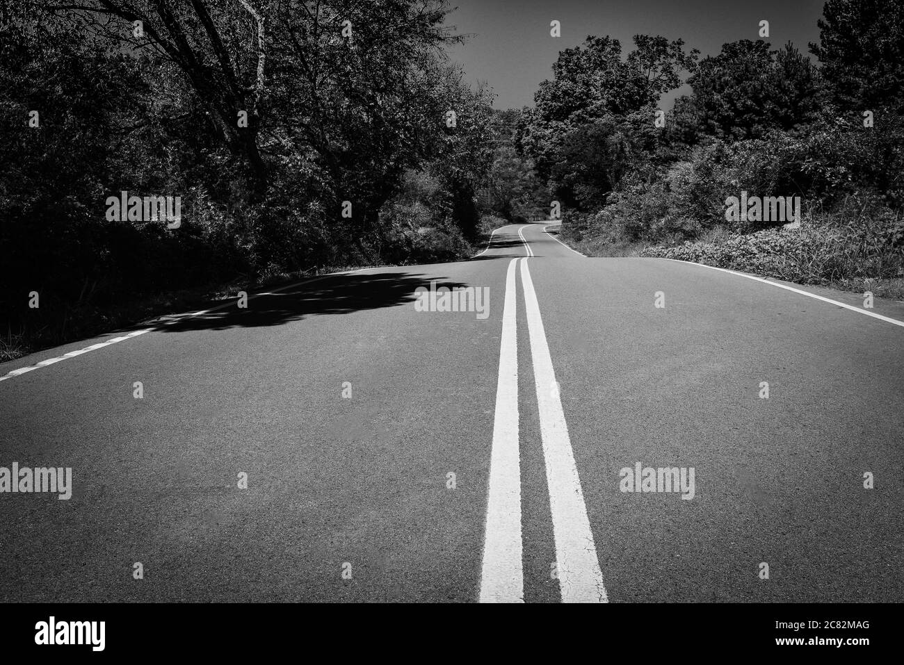 A low angle view from the middle of the yellow striped country highway ...