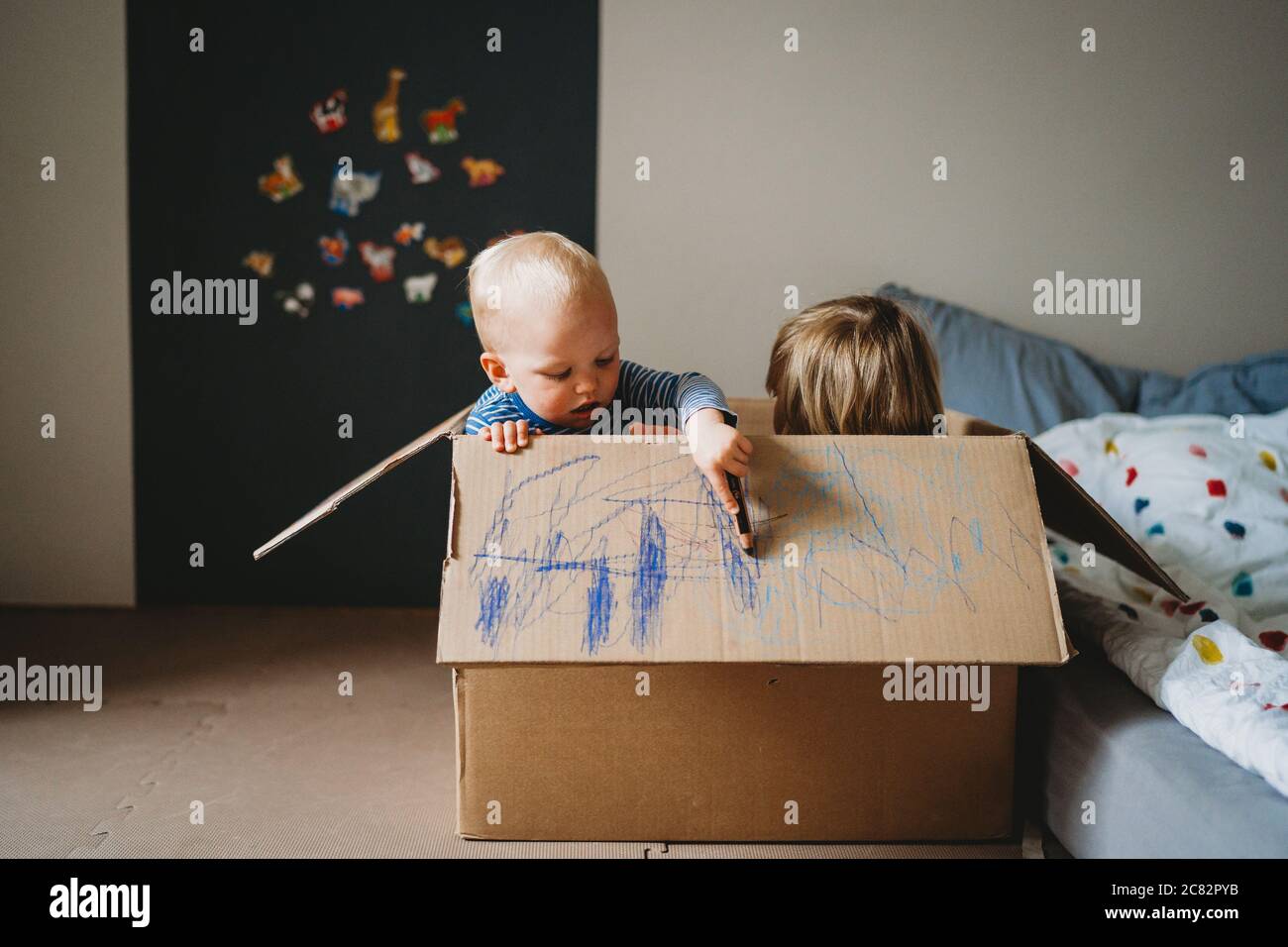 Kids playing and drawing in a box during lockdown Stock Photo - Alamy