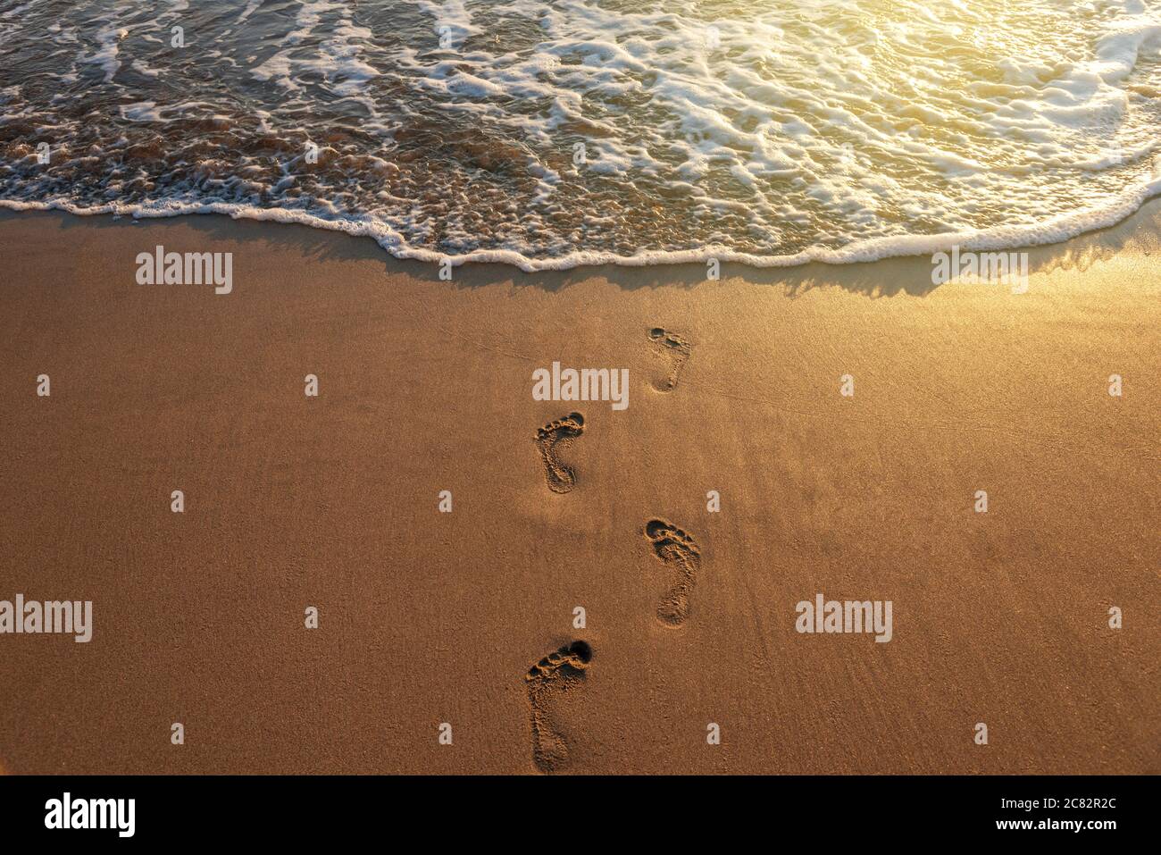 beach, wave and footsteps at sunset time in summer Stock Photo - Alamy