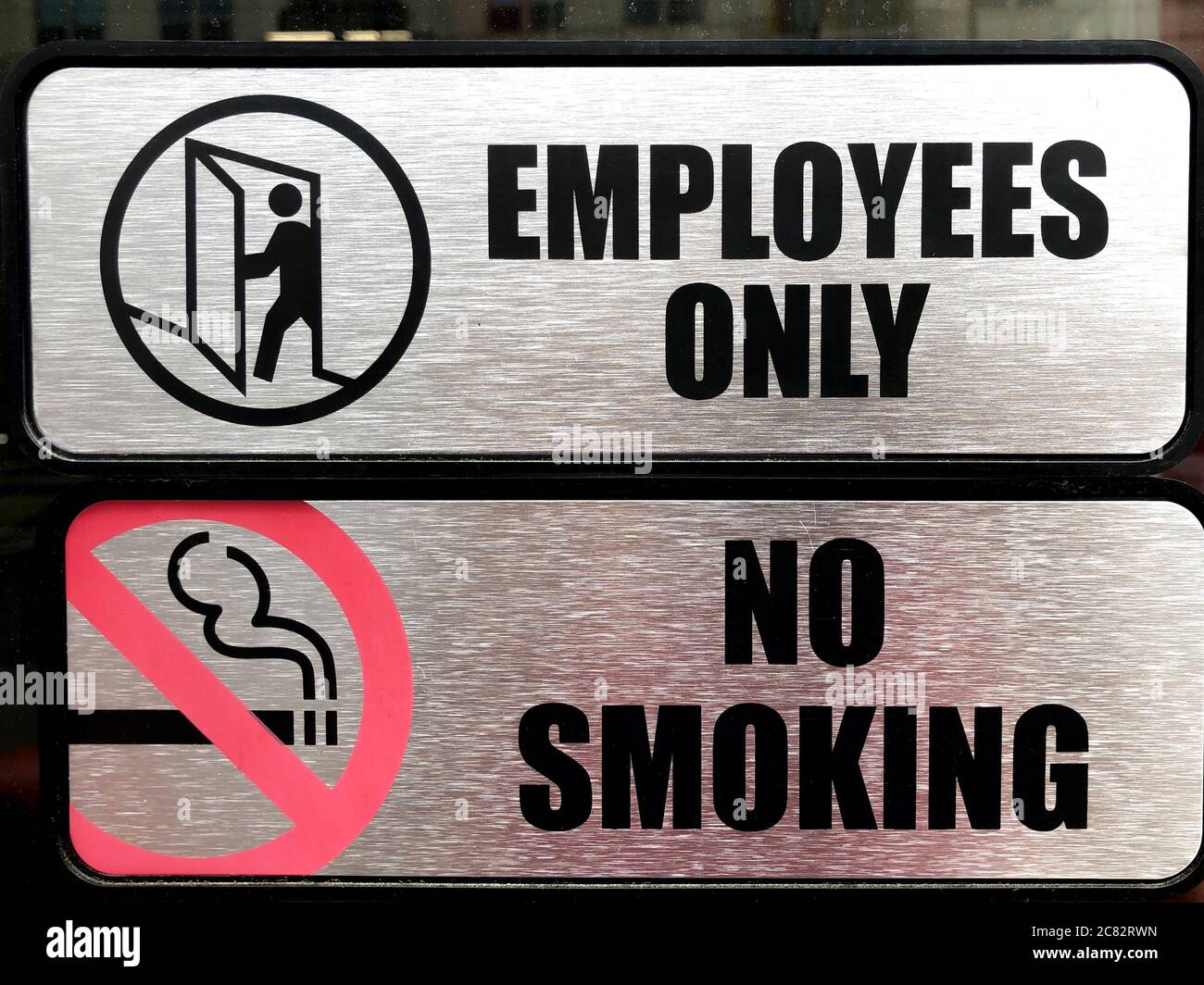 Closeup of "Employees Only" and "No Smoking" signs located on an ...