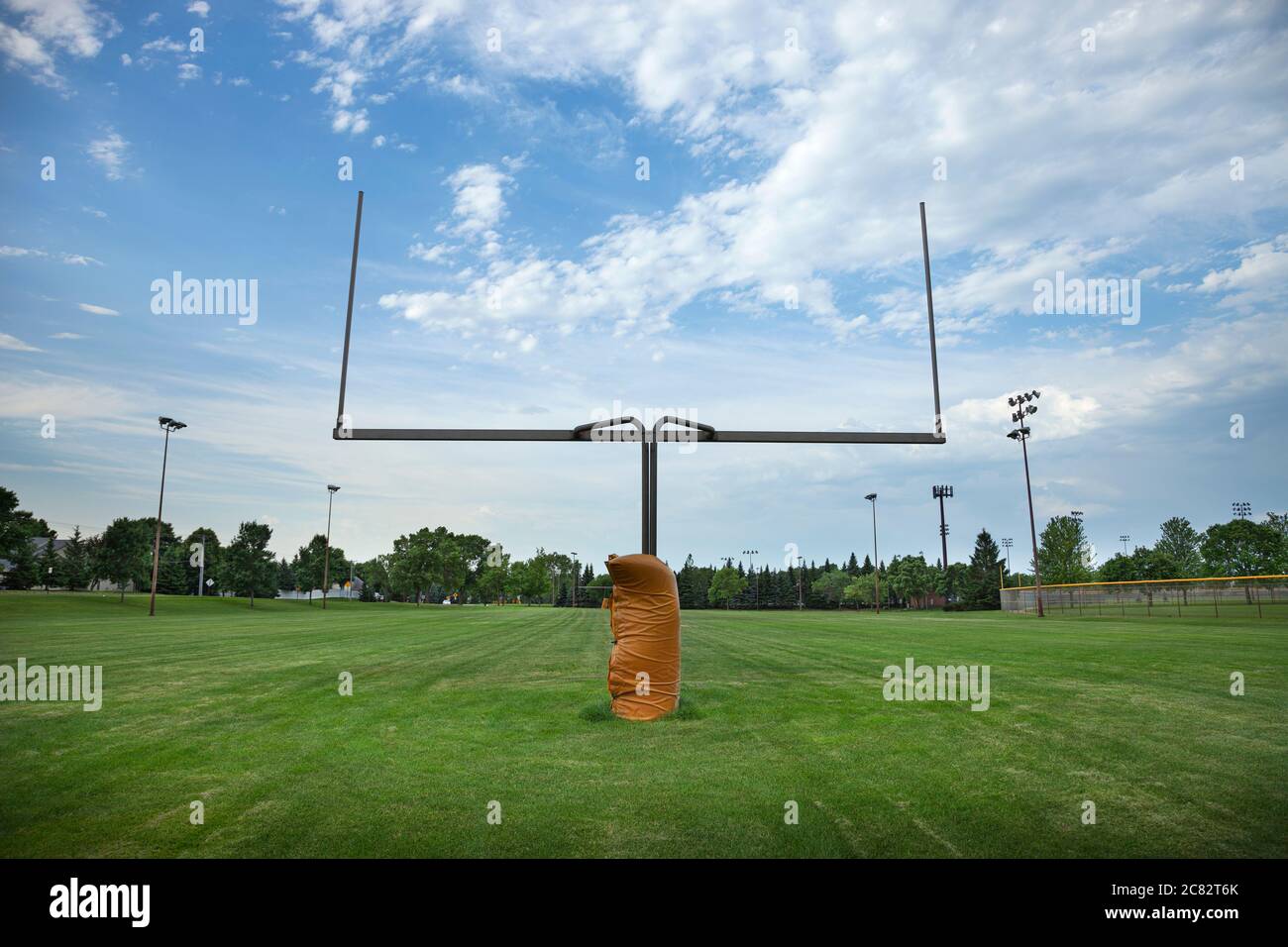 Wide angle view of a goalpost on a football field with beautiful clouds ...