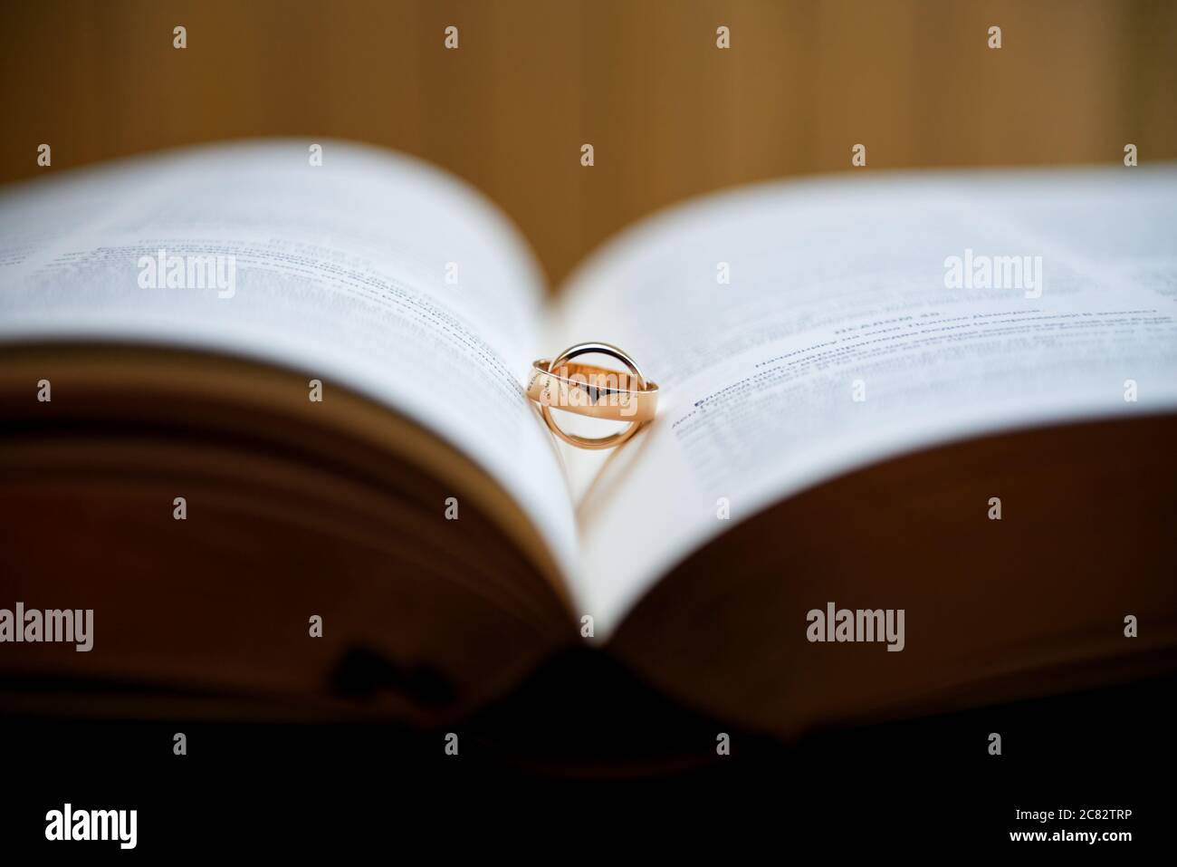 wedding rings on a book Stock Photo - Alamy
