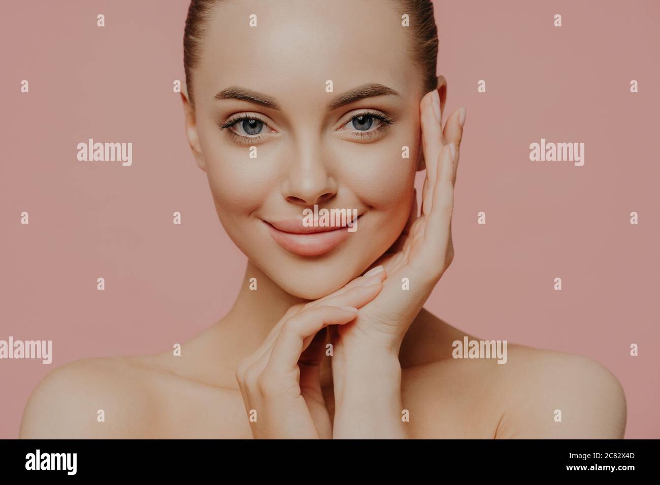 Beautiful young woman with clean fresh skin looking at the camera ...