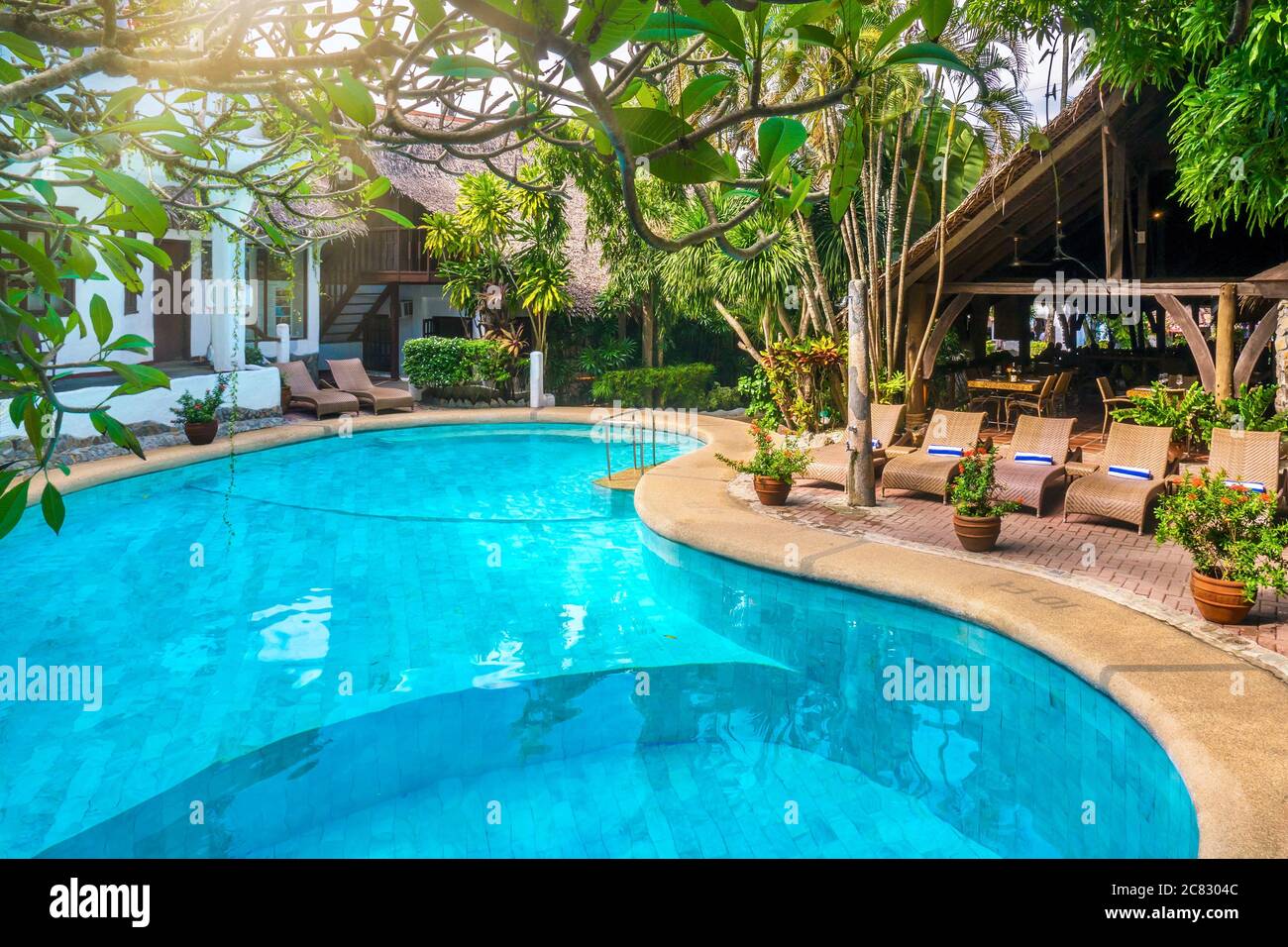 Beautiful tropical resort swimming pool with vibrant turquoise water ...