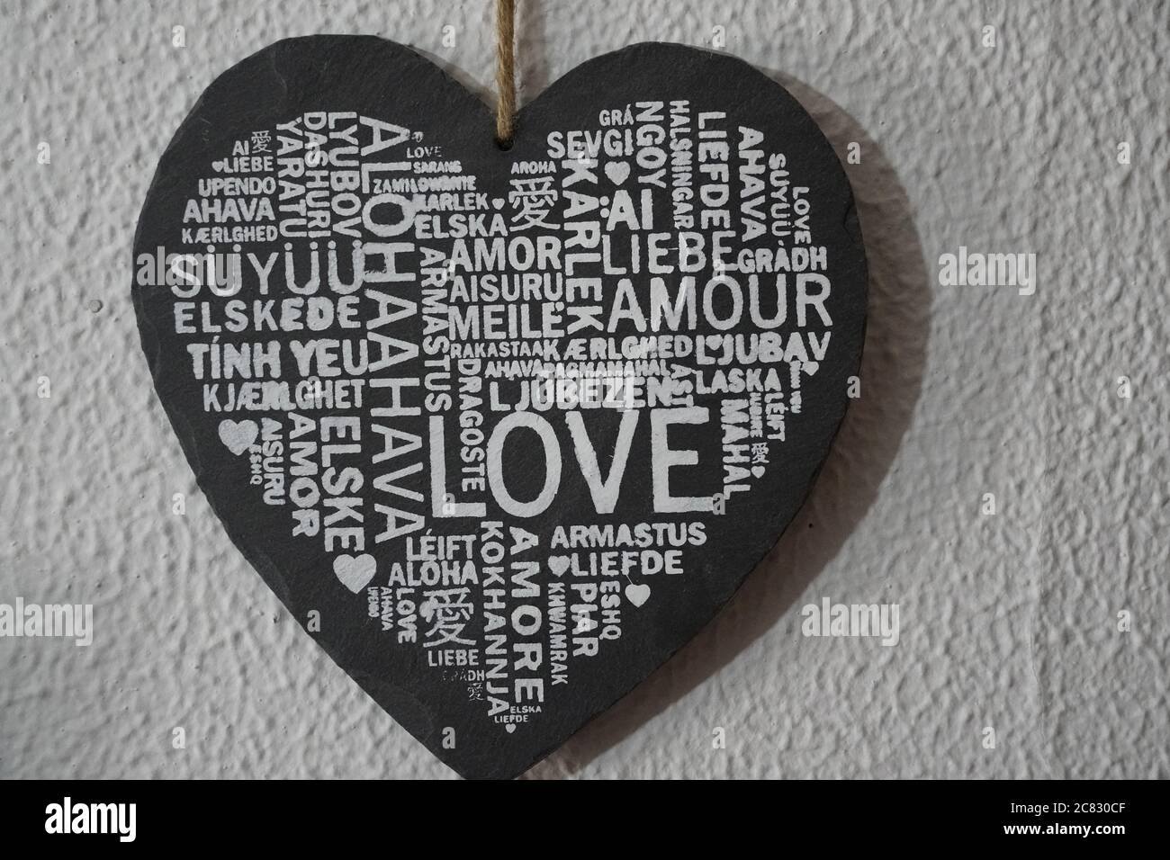 Word "love" written in different languages on a heart-shaped black ...