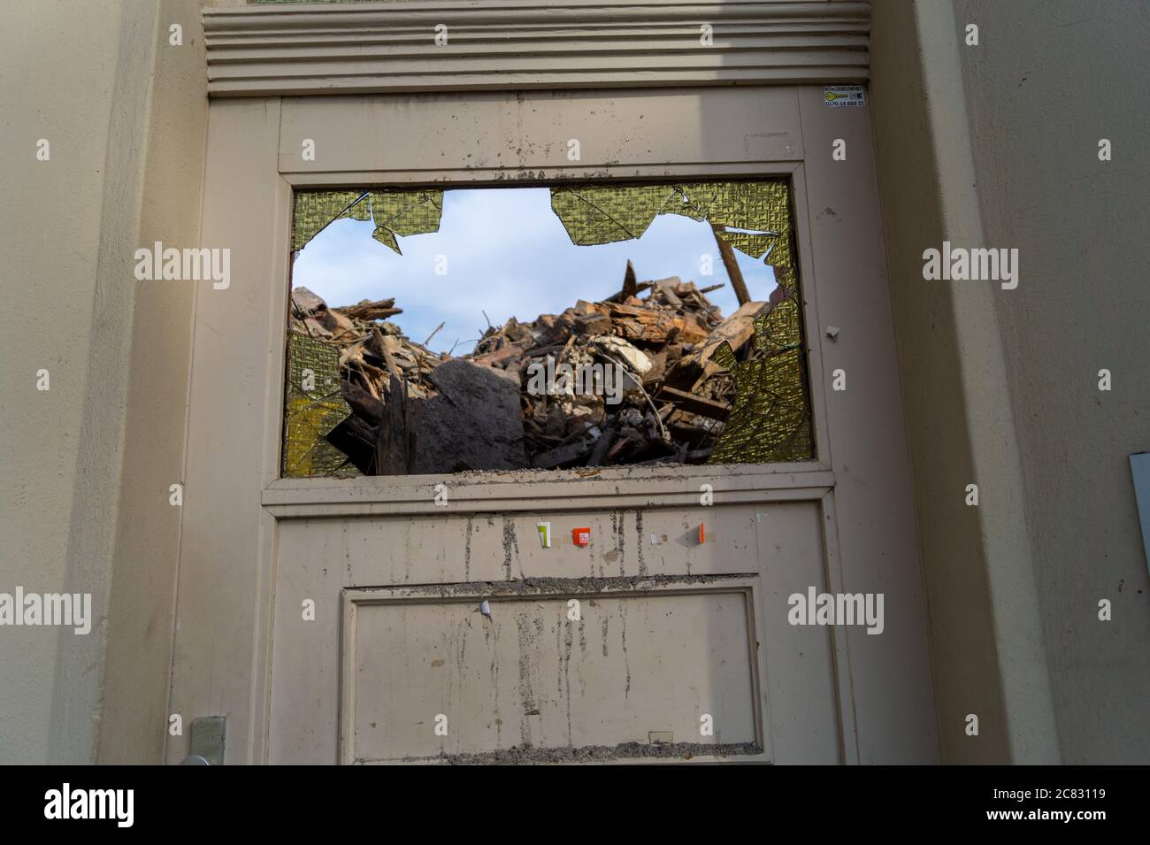 View through a broken window of a door in an old abandoned house Stock ...