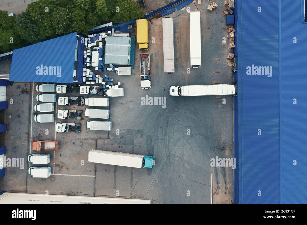 Distribution warehouse area with cargo trucks and cars, aerial top view ...
