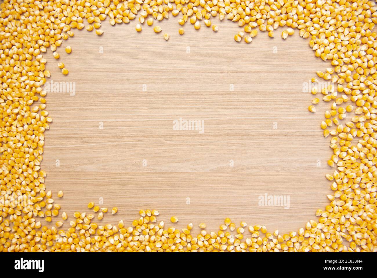 Corn grains scattered on a wooden surface with a space for text in the ...