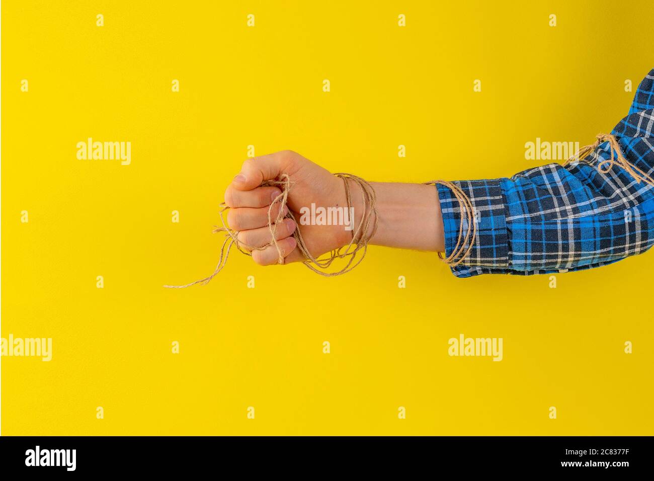 a person's hand in the rope tighten against the colorful background ...
