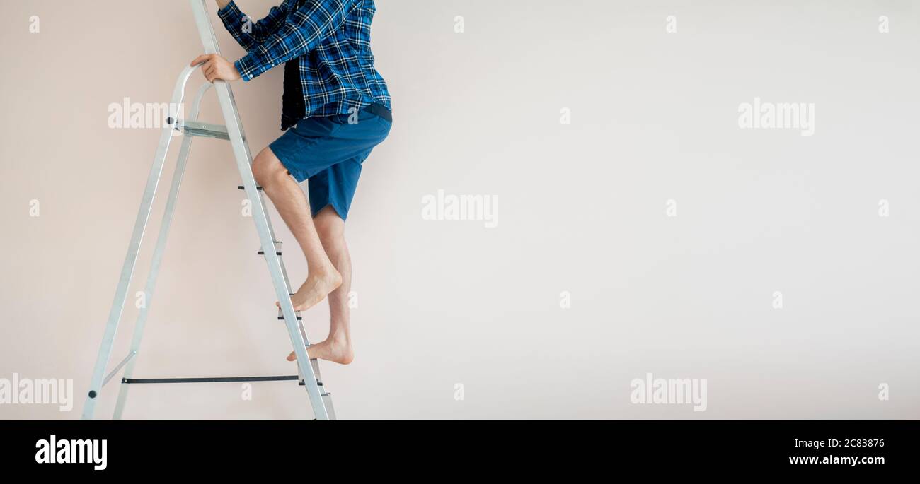 a close up workers feet on the ladder climb to the top against the wall ...