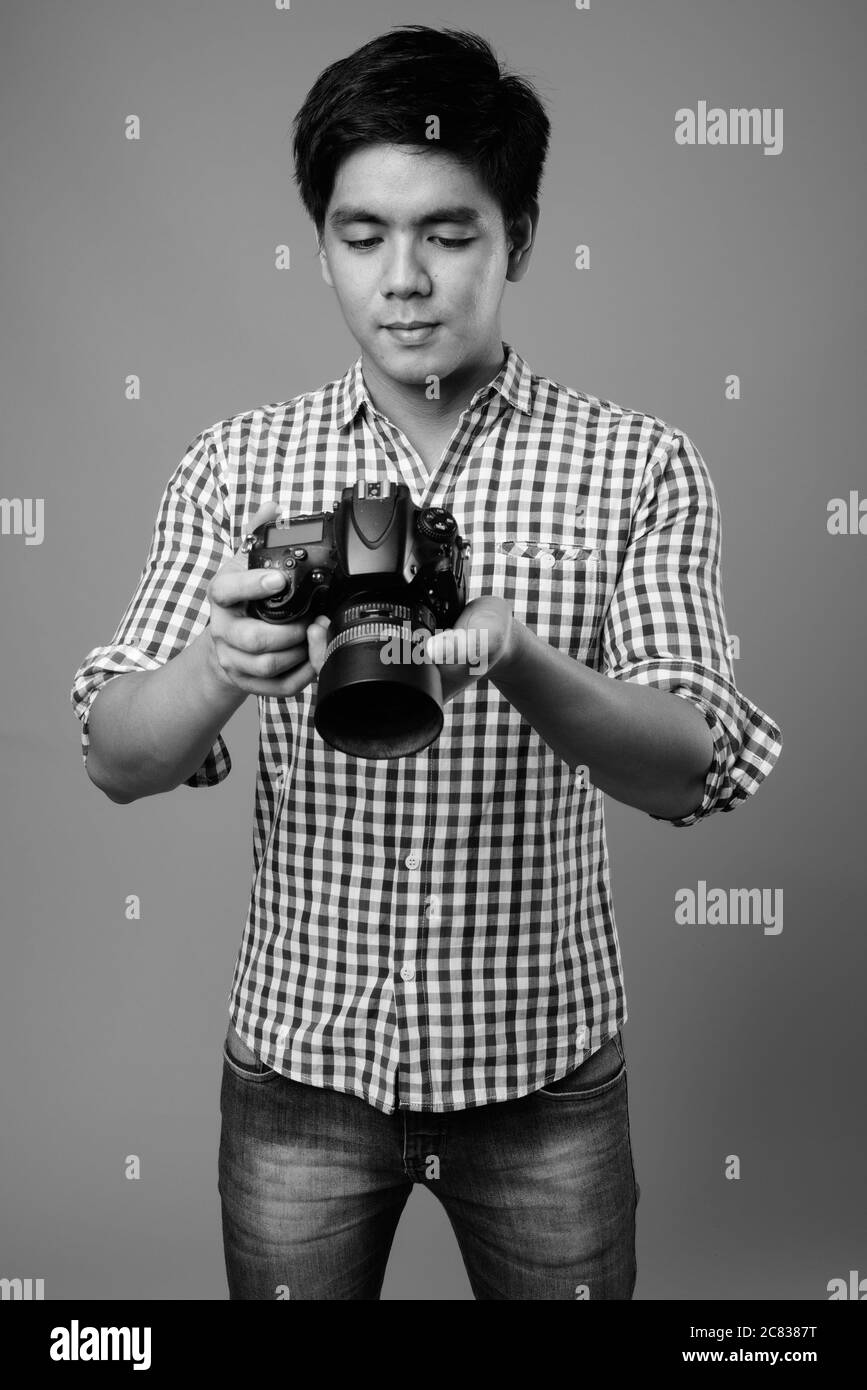 Portrait of young handsome Filipino hipster man with camera Stock Photo ...