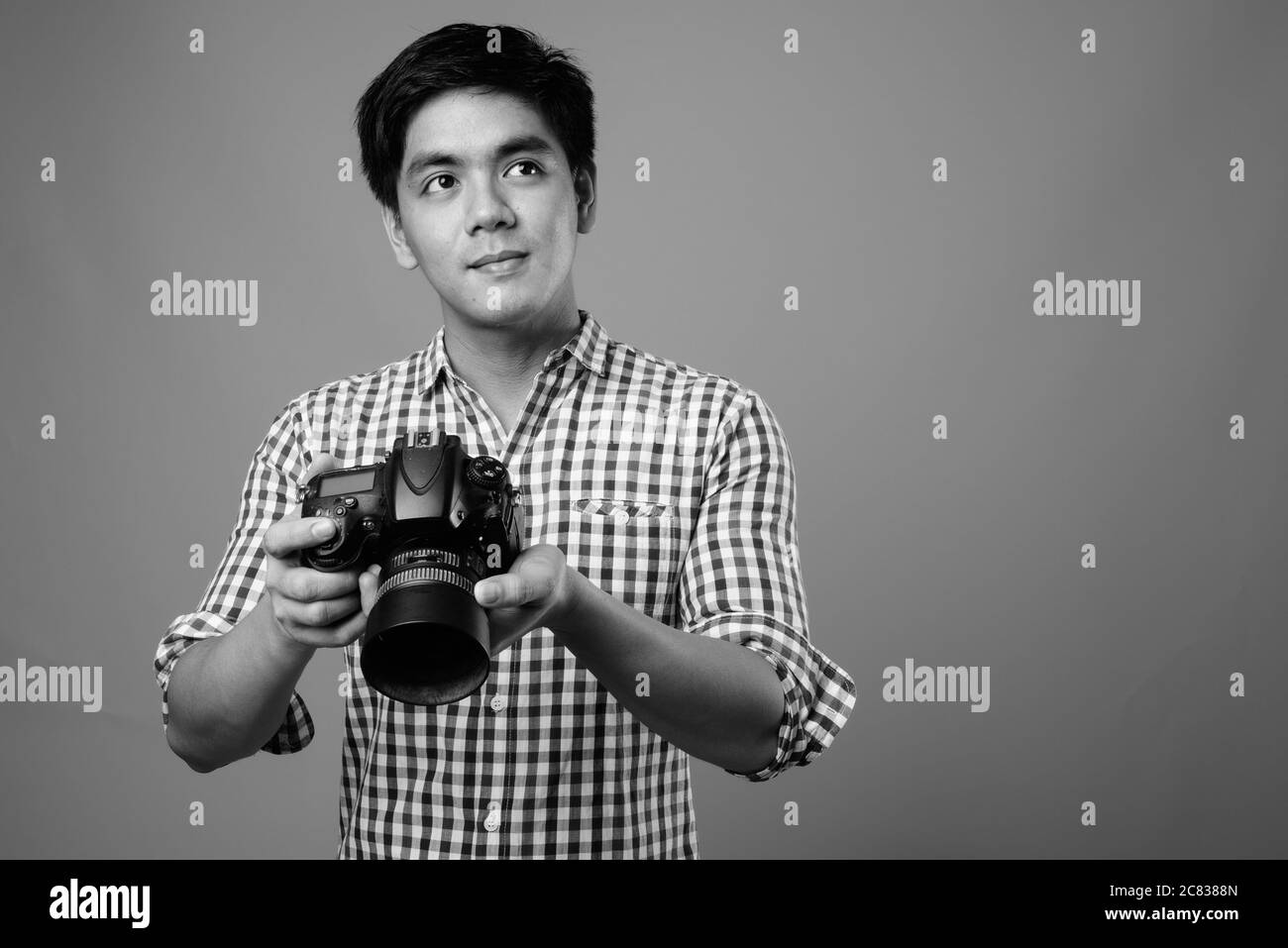 Portrait of young handsome Filipino hipster man with camera Stock Photo ...