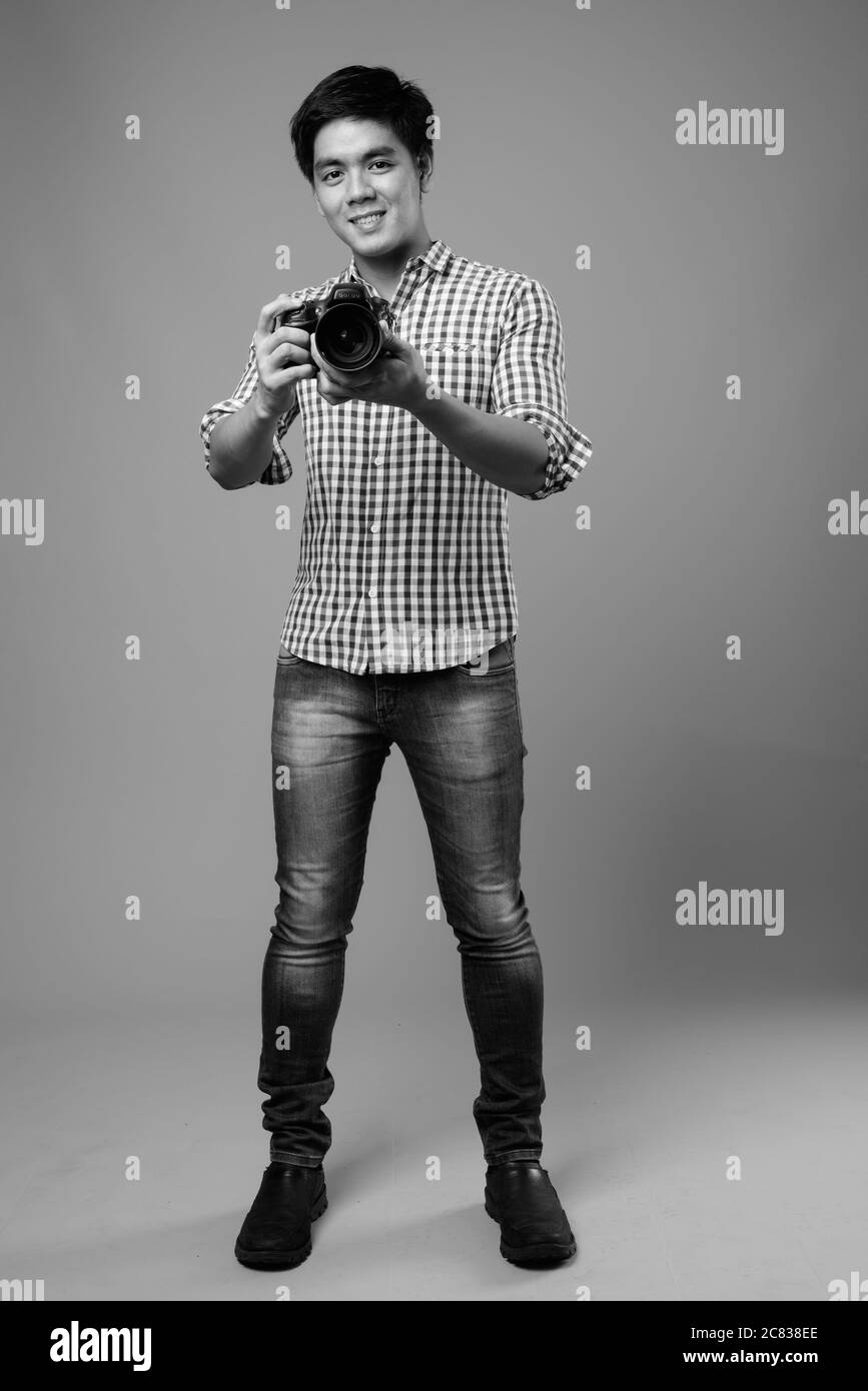 Portrait of young handsome Filipino hipster man with camera Stock Photo ...