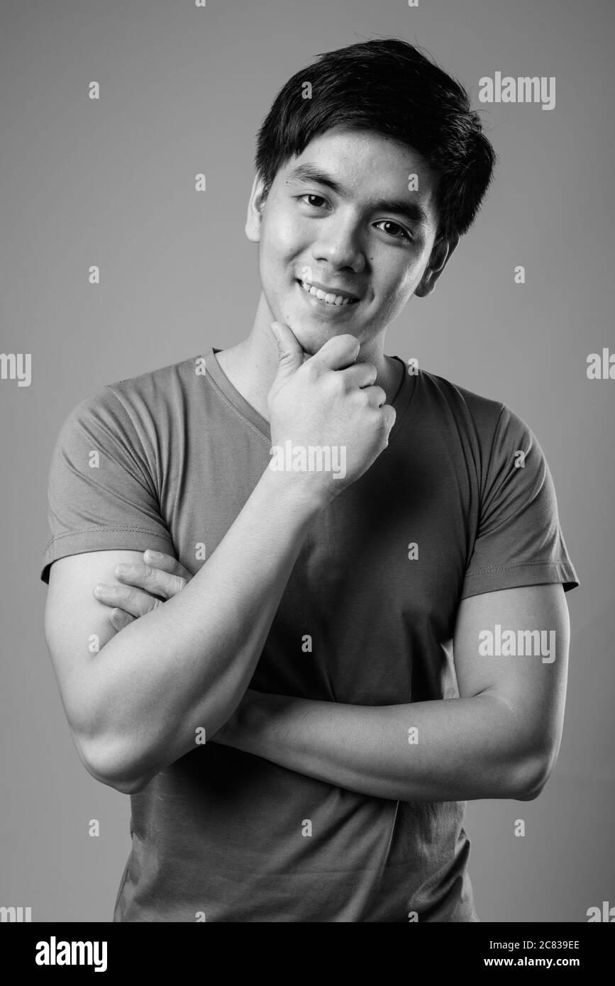 Portrait of young handsome Filipino man against gray background Stock ...
