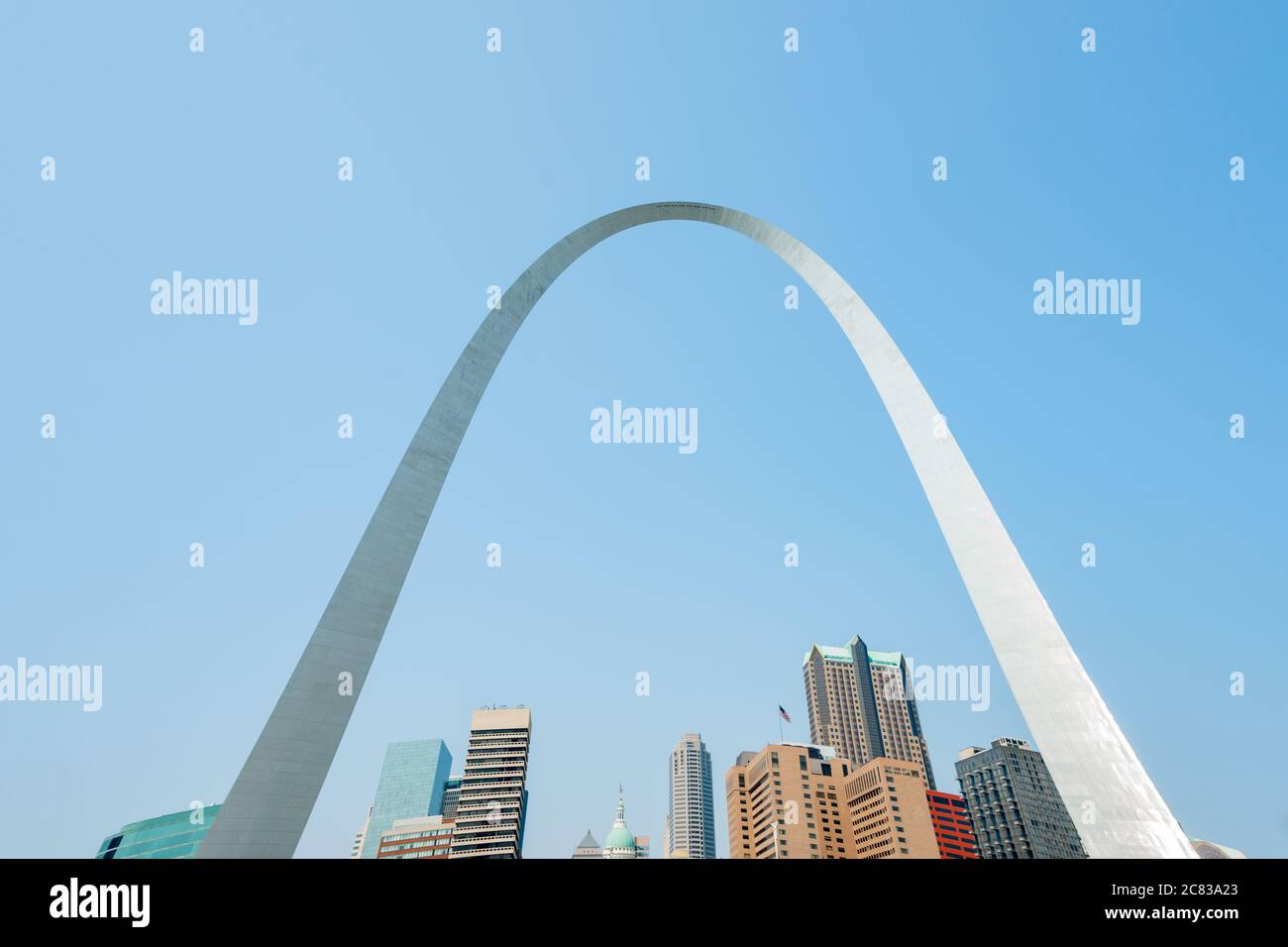 St Louis Gateway Arch with sun on one side as it reaches over downtown ...