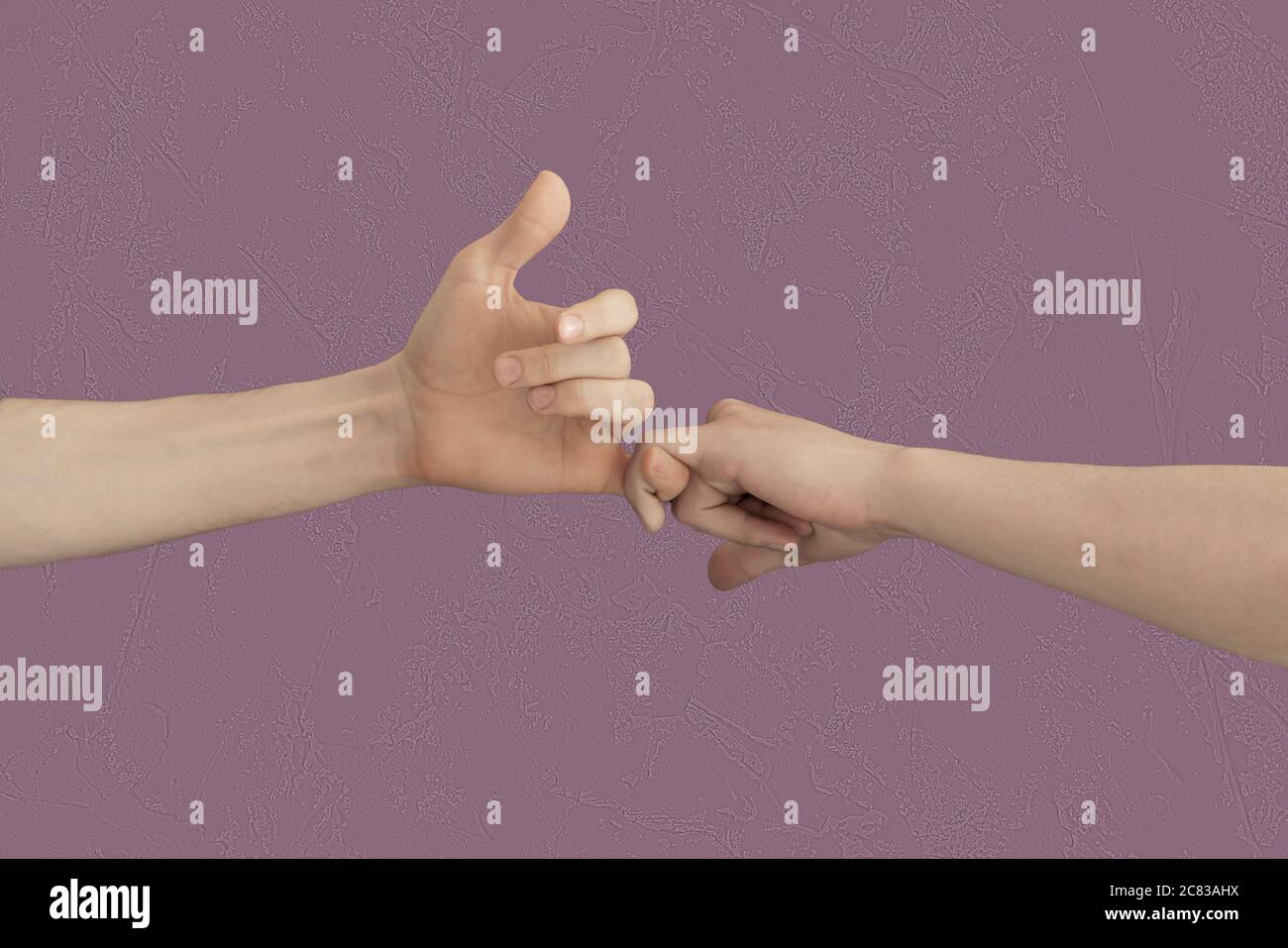 a close up two people hook little fingers of each other, isolated ...