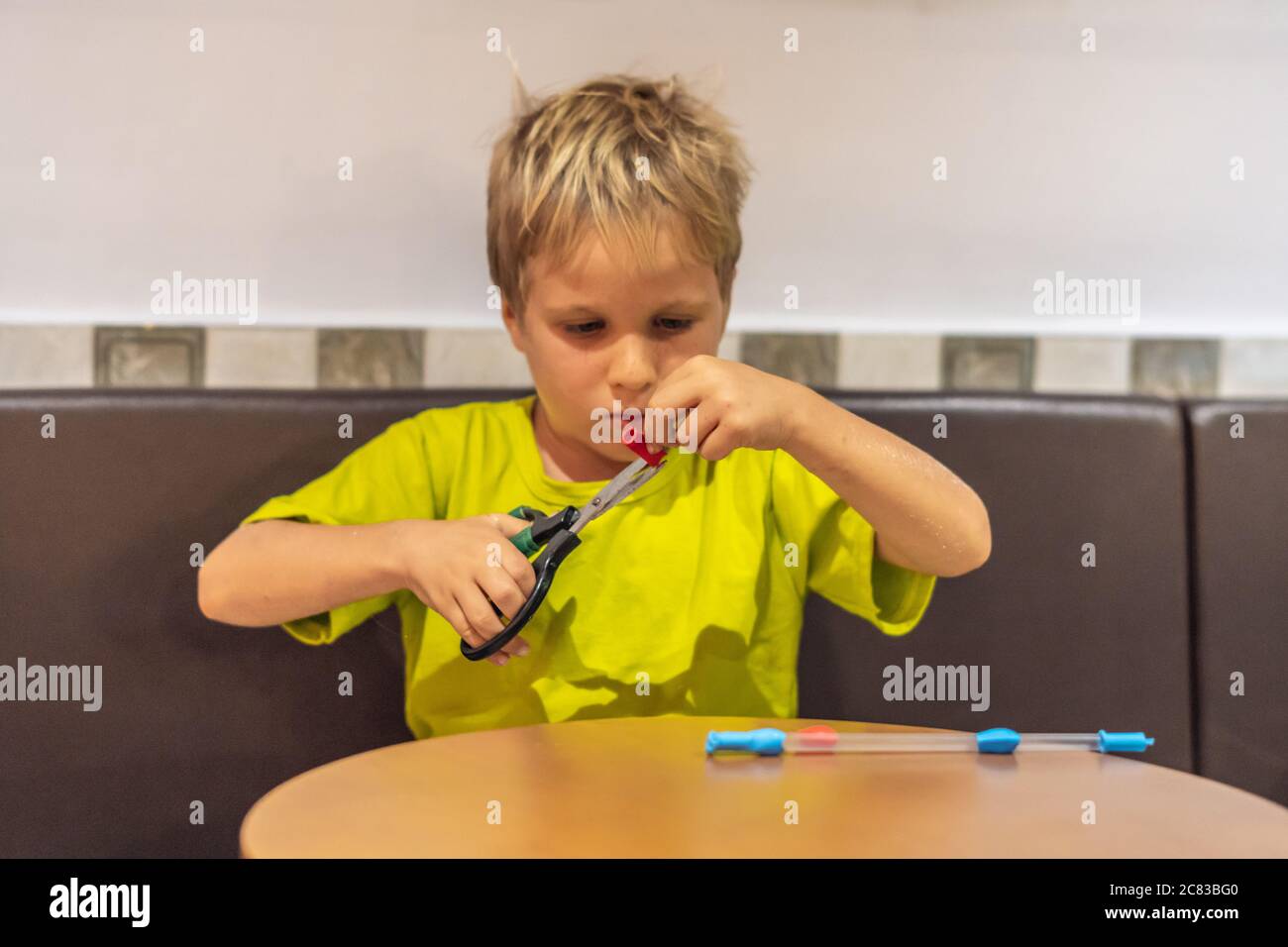 Little boy in green yellow tshirt cut recycle materials in arts and ...