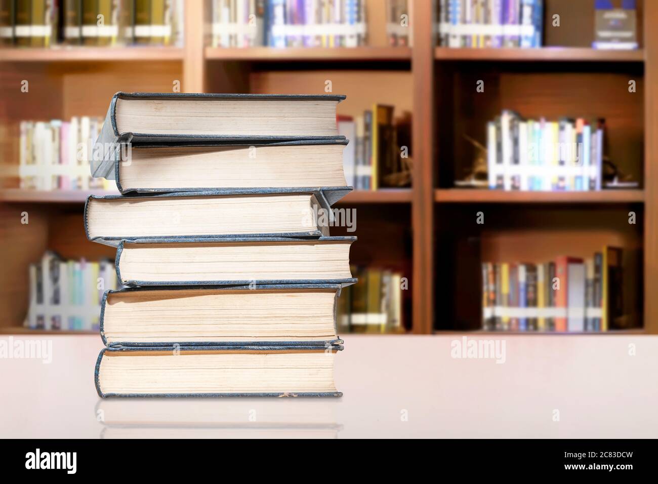 Desk with a stack of books with bookshelf background. Back to School ...