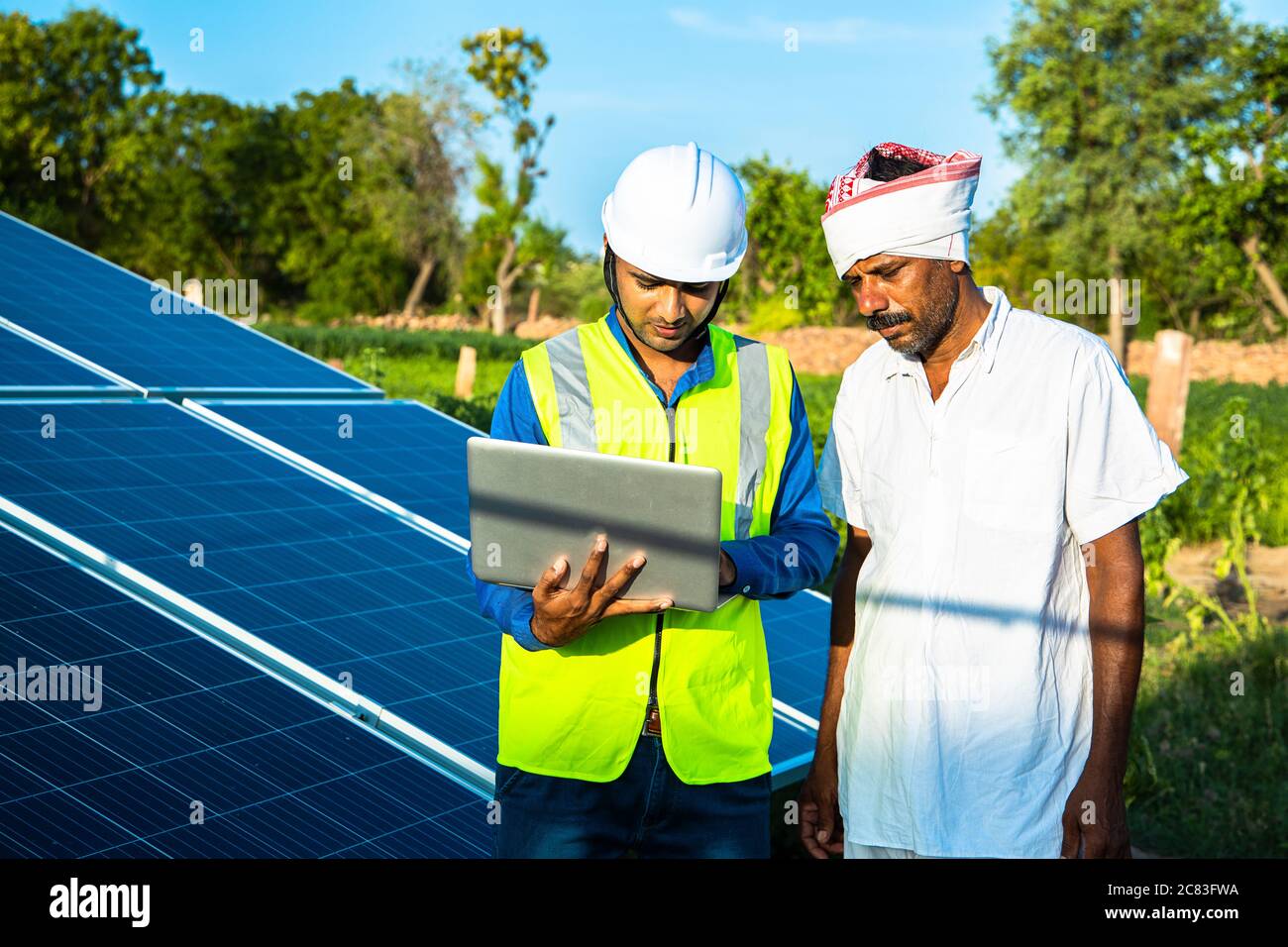 young male technician worker wearing green vests and helmet checks the ...