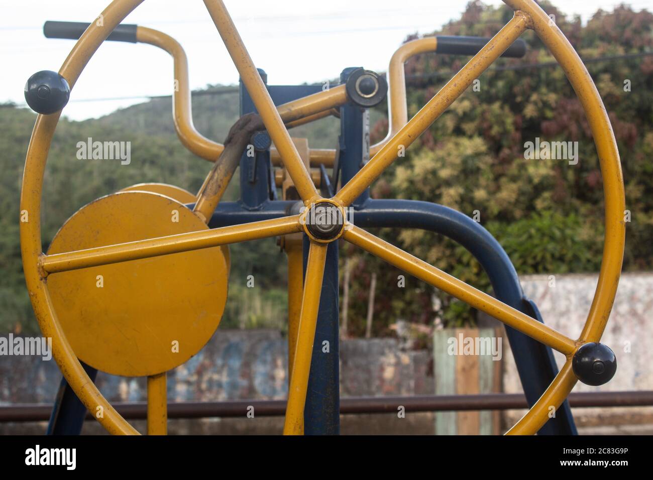 Closeup shot of a wheel-shaped yellow outdoor exercise equipment at a ...