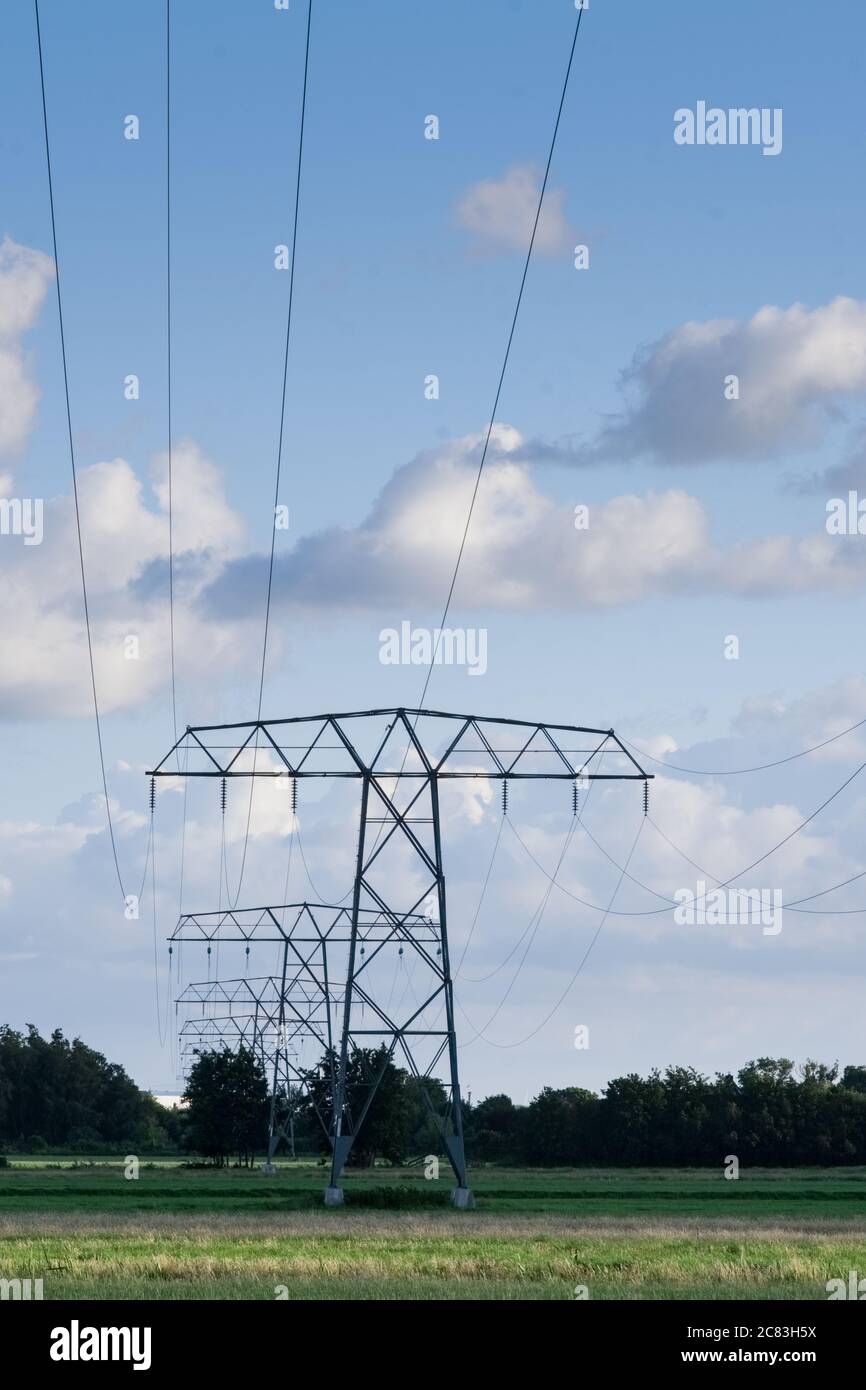 A row of high voltage pylons, one behind the other, connected to ...