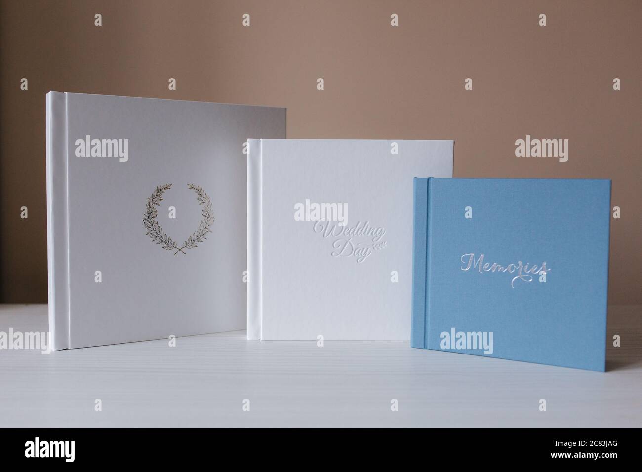 Three different photobooks on white wooden table. Comparison Stock ...