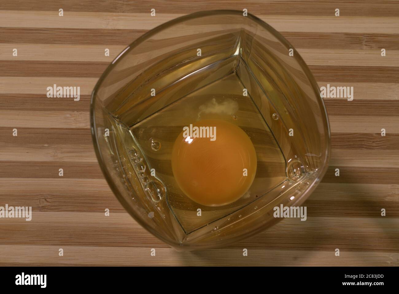Raw egg in a glass beaker. On a black background Stock Photo - Alamy