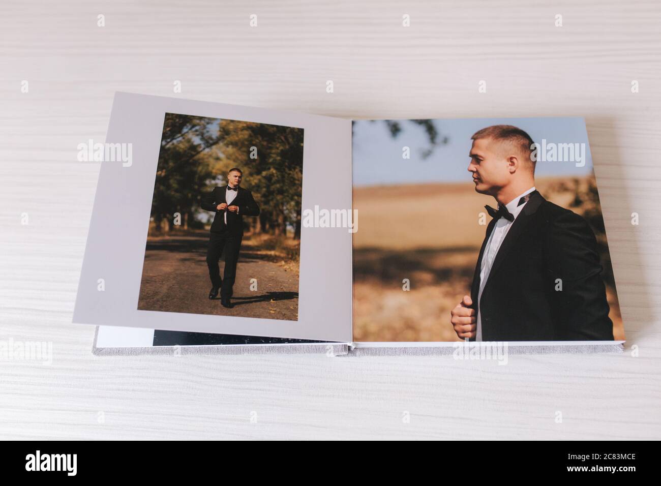 Open photobook with groom on white wooden table. Wedding book Stock ...
