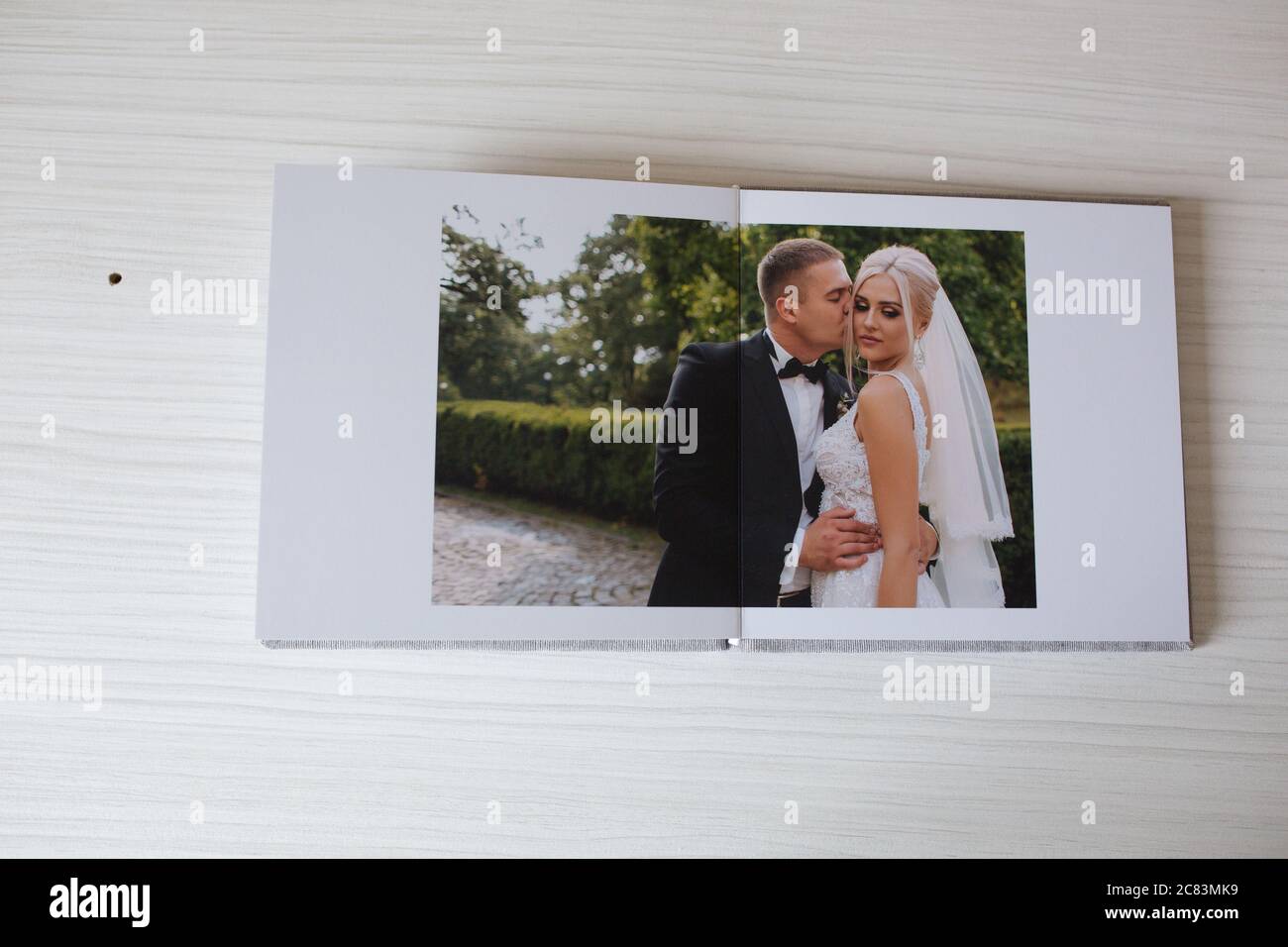 Open photobook with wrdding photo of beautiful couple on white wooden ...