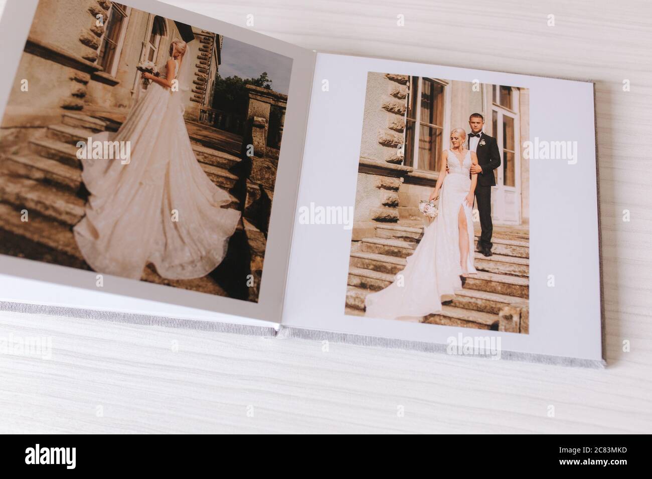 Open photobook with wrdding photo of beautiful couple on white wooden ...