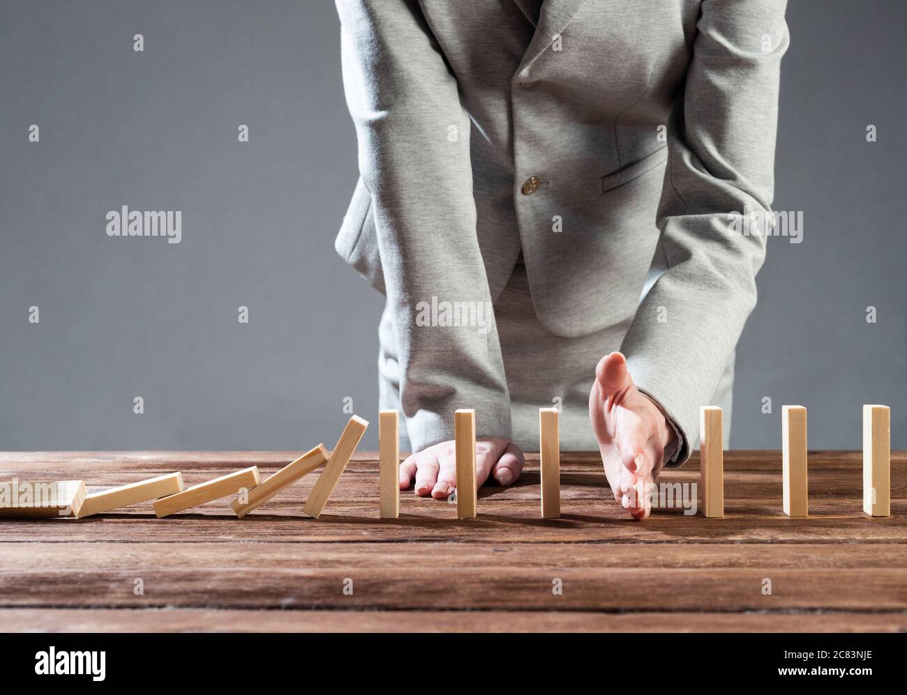Business woman interrupting domino effect Stock Photo - Alamy