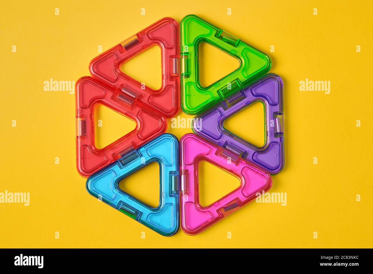 Top view of colorful magnetic building blocks on yellow background ...