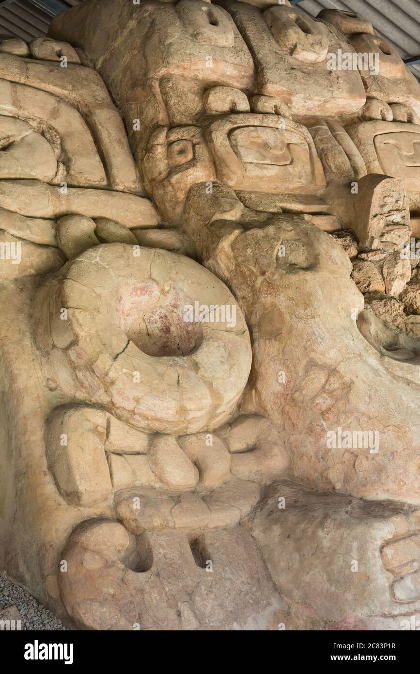 Large stucco masks on the ruins of a Mayan pyramid on the town square ...