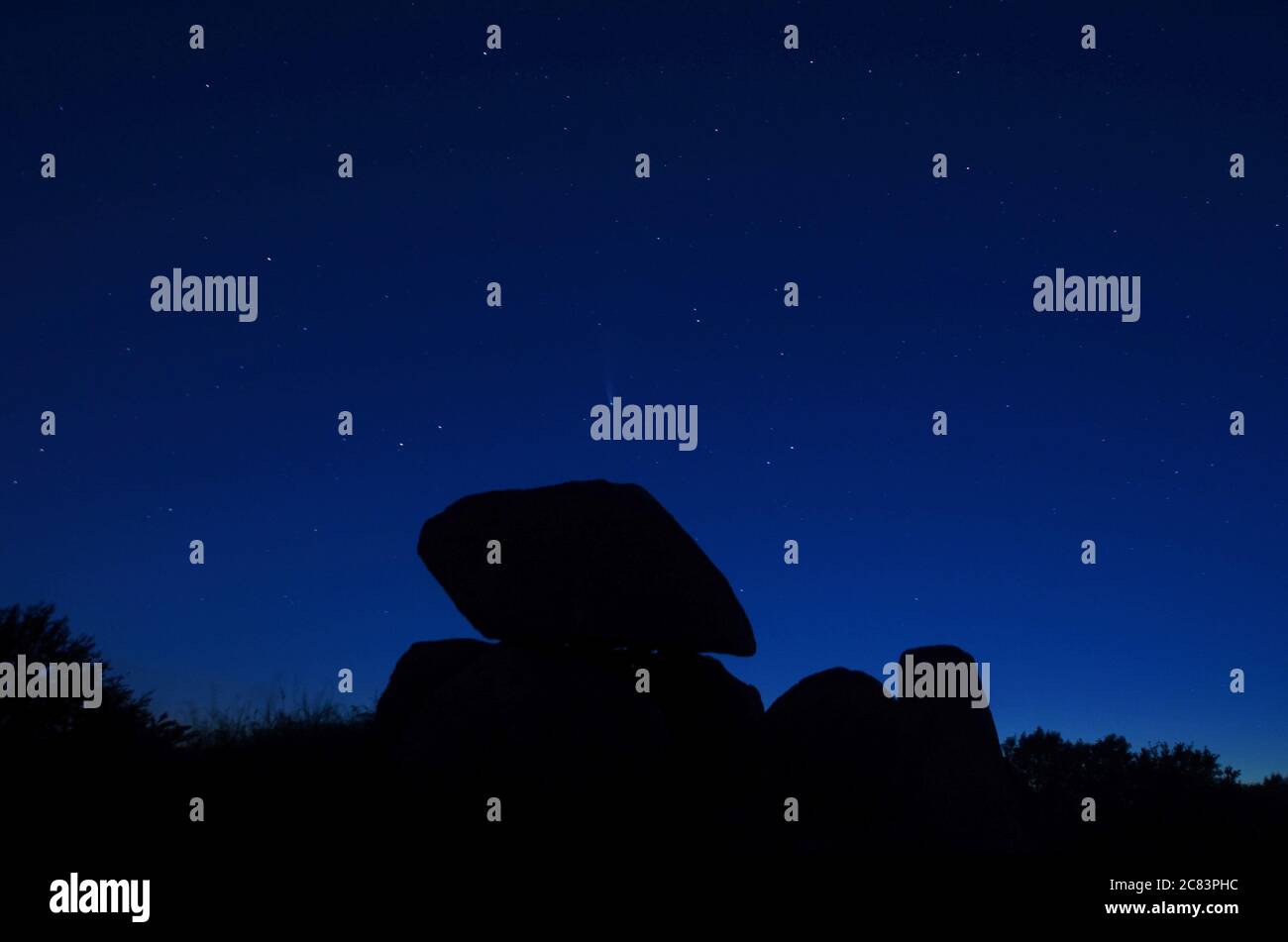Night landscape with iron age barrow at midnight with comet Neowise in ...