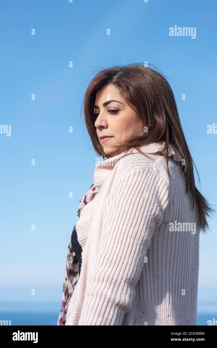Side view of woman looking down outdoors Stock Photo - Alamy