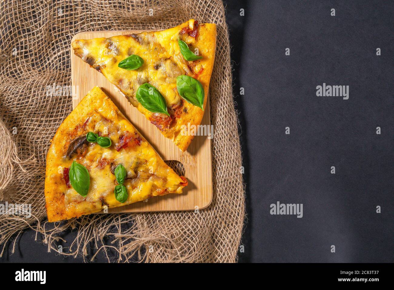 Two slice pizza basil leaves on black background, top view. flat lay ...