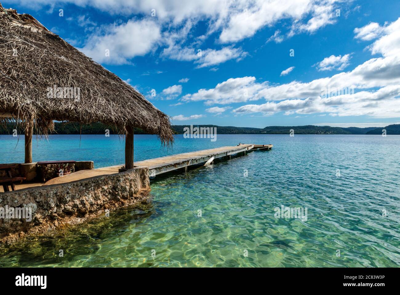 Beautiful scenery of a wooden resort dock on the beach on a sunny day ...