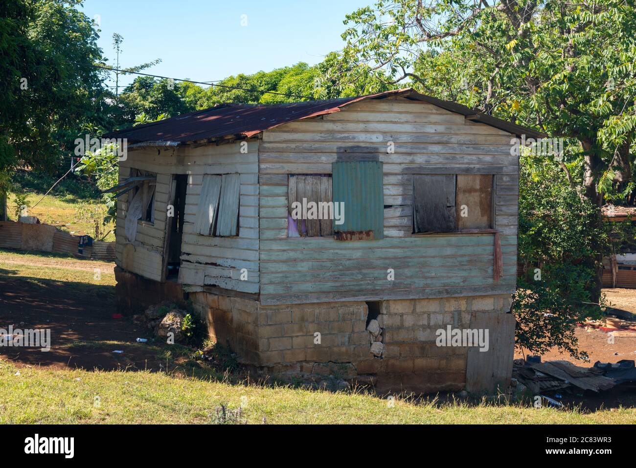 Old weathered wooden house surrounded by green-leafed trees Stock Photo ...