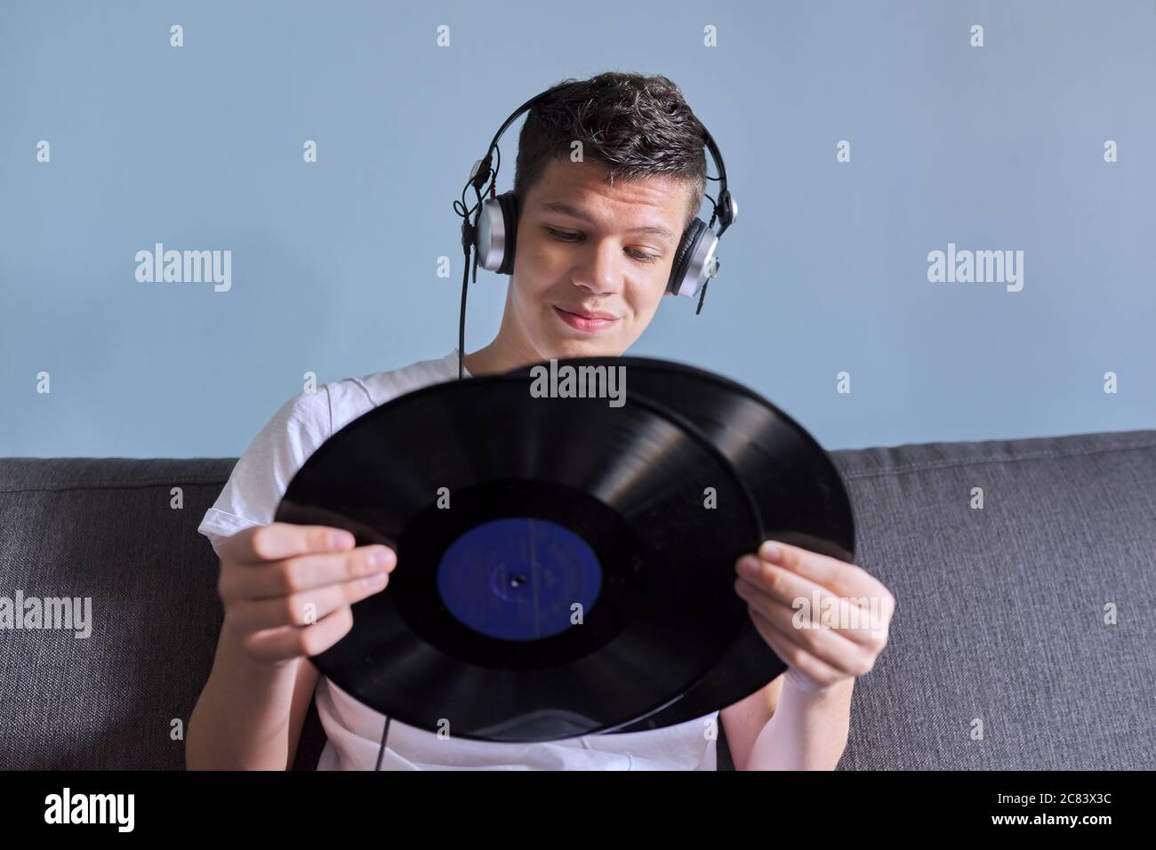 Creative teen boy with vinyl records, young man in headphones ...